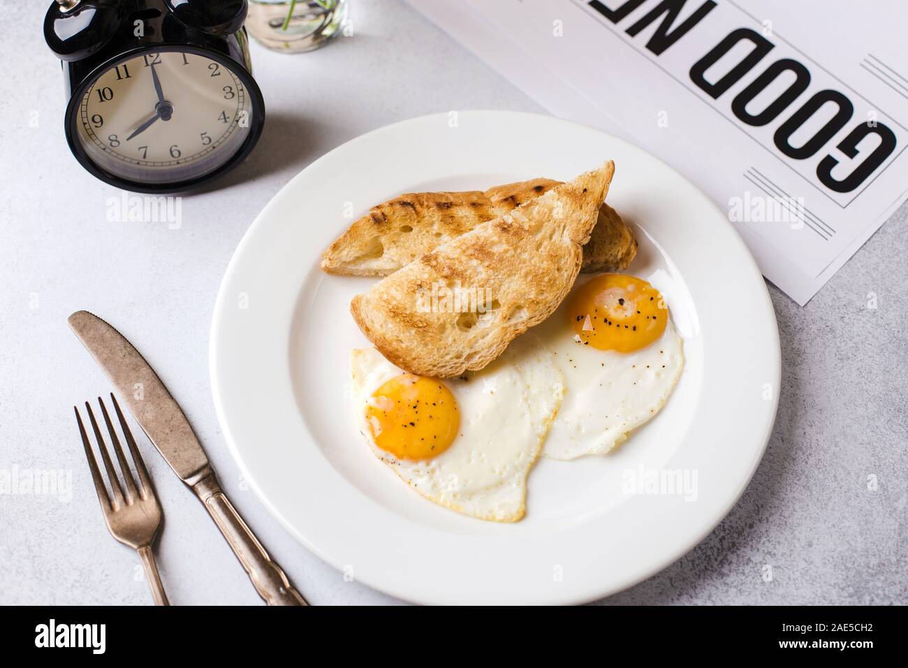 Breakfast time. Two fried eggs with toast for breakfast on a textured ...