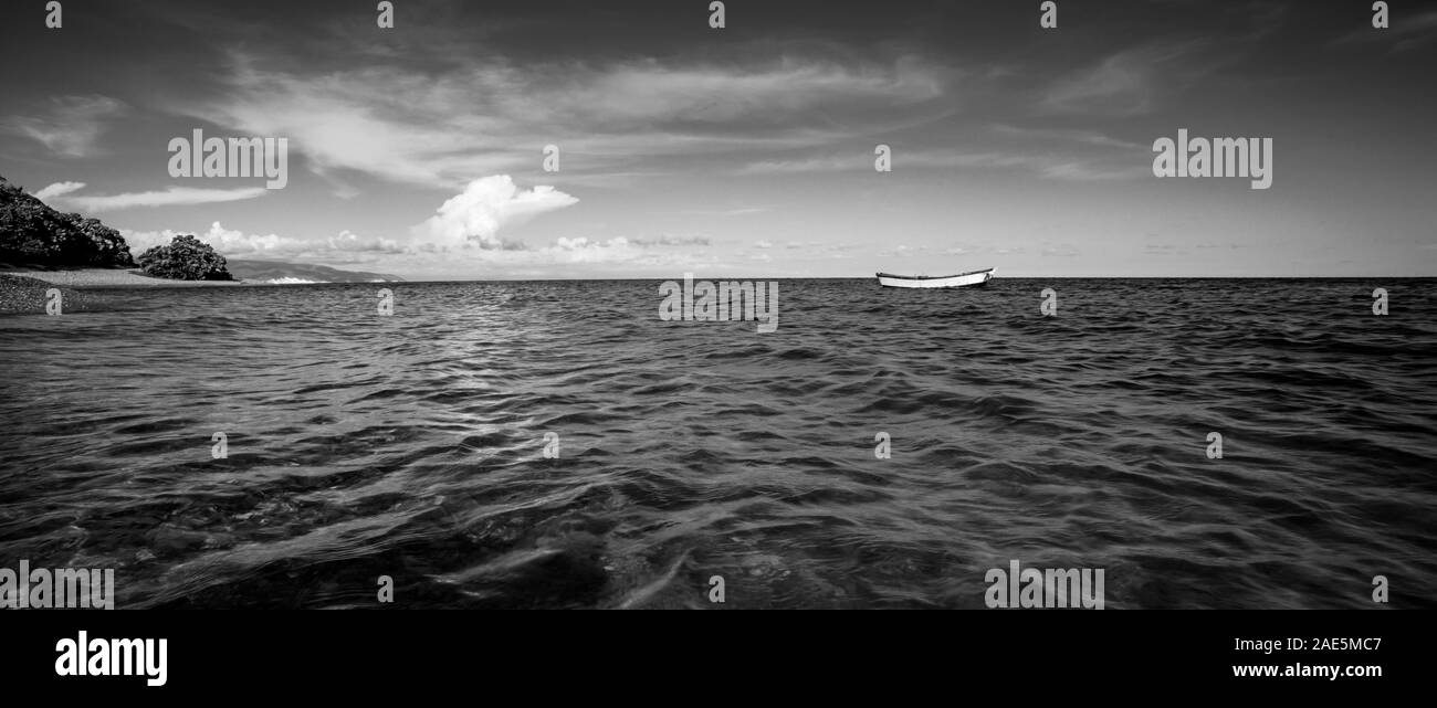 dramatic black and white seascape of a small fishing boat in the ...