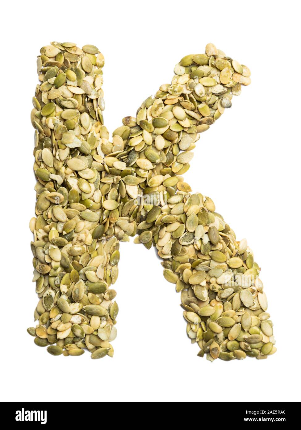 Letter K of the English alphabet from pumpkin seeds on a white isolated ...