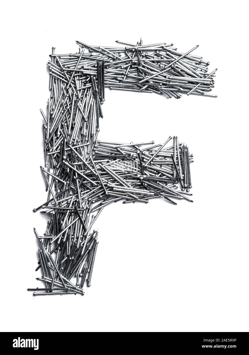 Letter F of the English alphabet from small iron nails on a white ...