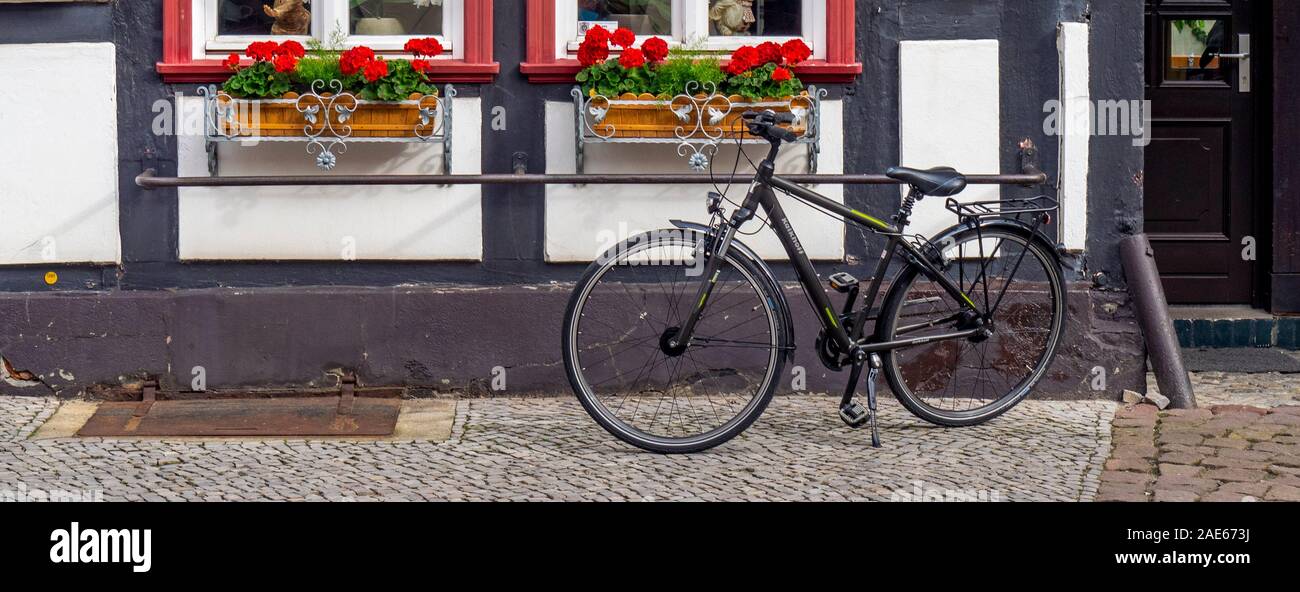 Bicycle under window with pot plants in a timber frame building in ...