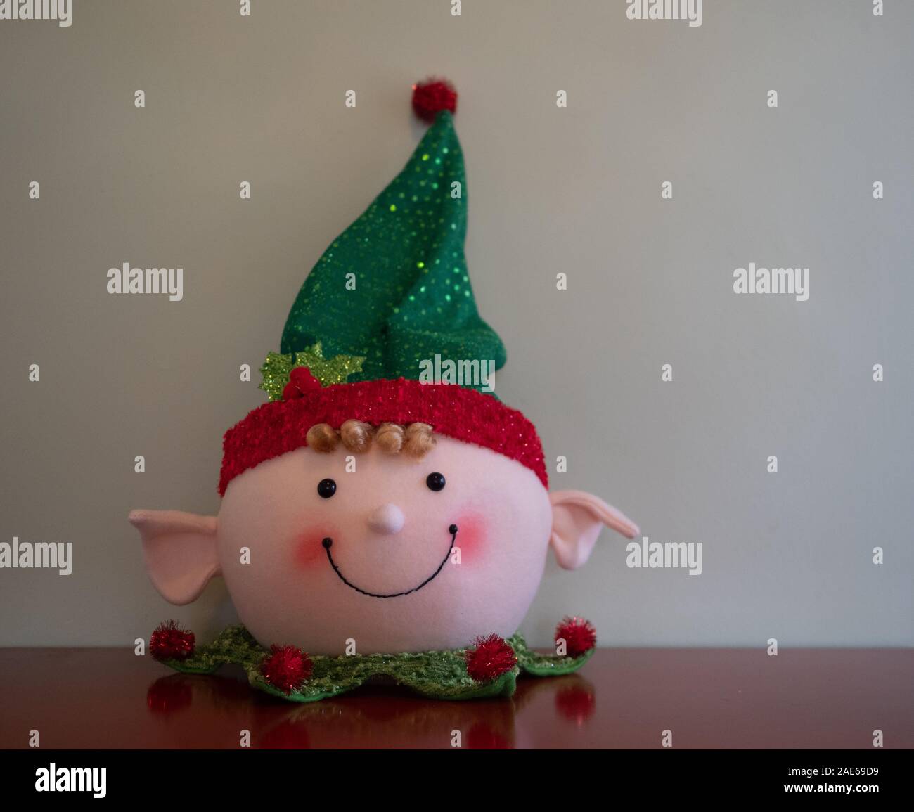 Close up of a smiling Christmas elf with red and green Santa hat and ...