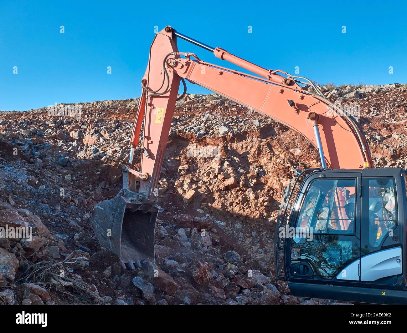 Excavator is moving a rock boulders during road construction on the ...