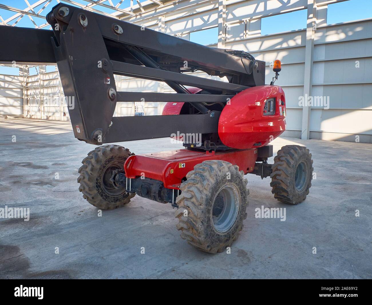 Red man lifting platform machinery at construction site Stock Photo - Alamy