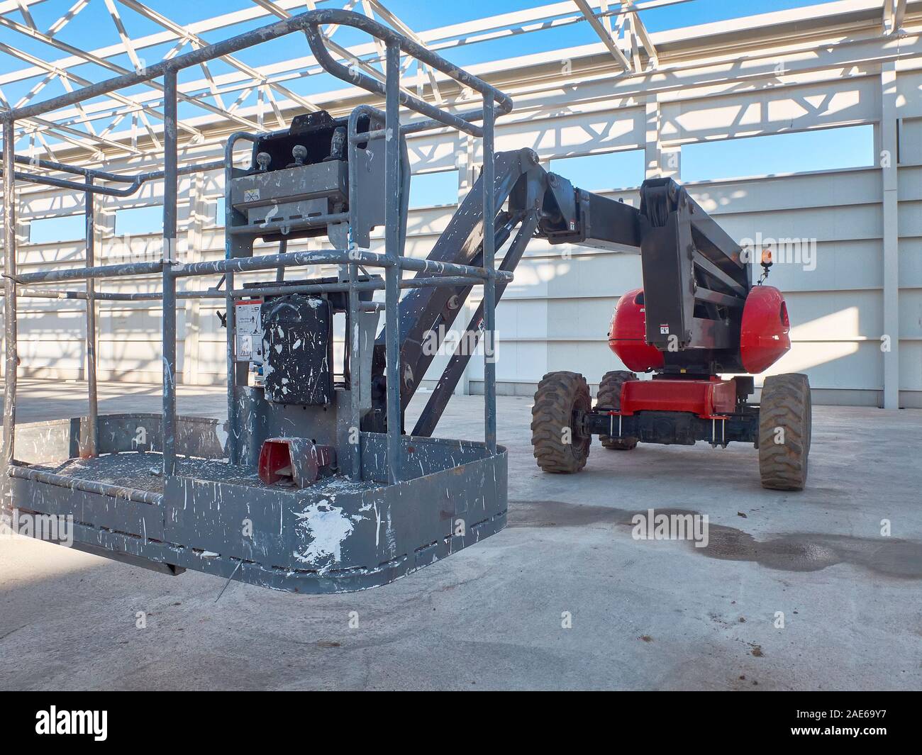Red man lifting platform machinery at construction site Stock Photo - Alamy