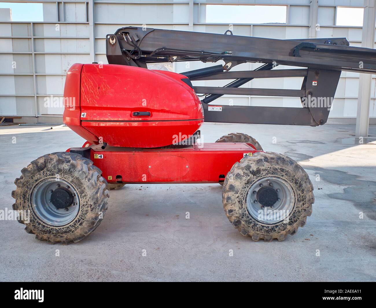 Red man lifting platform machinery at construction site Stock Photo - Alamy