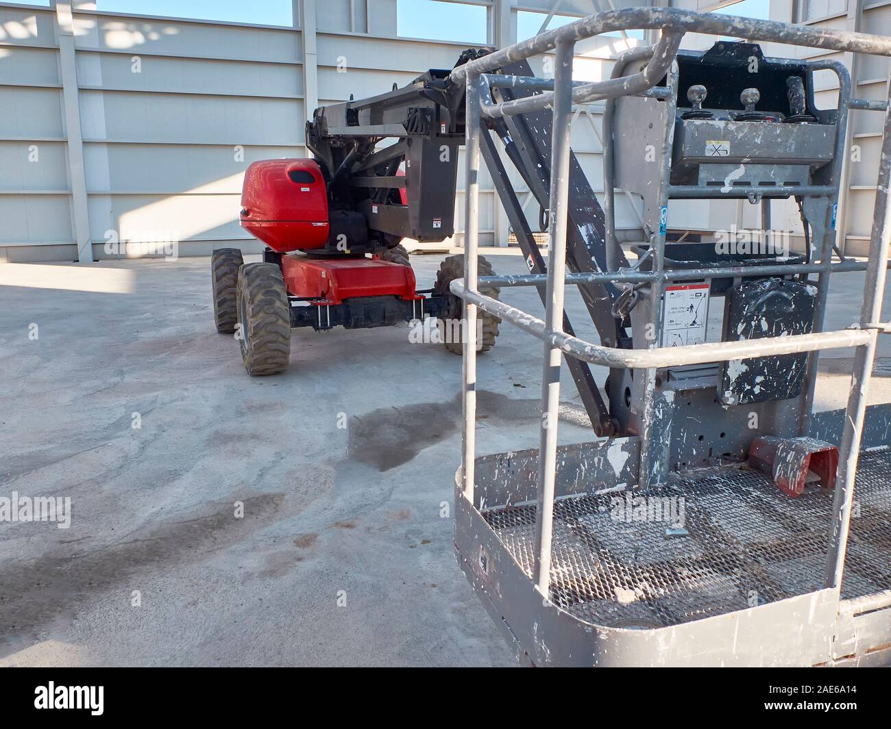 Red man lifting platform machinery at construction site Stock Photo - Alamy