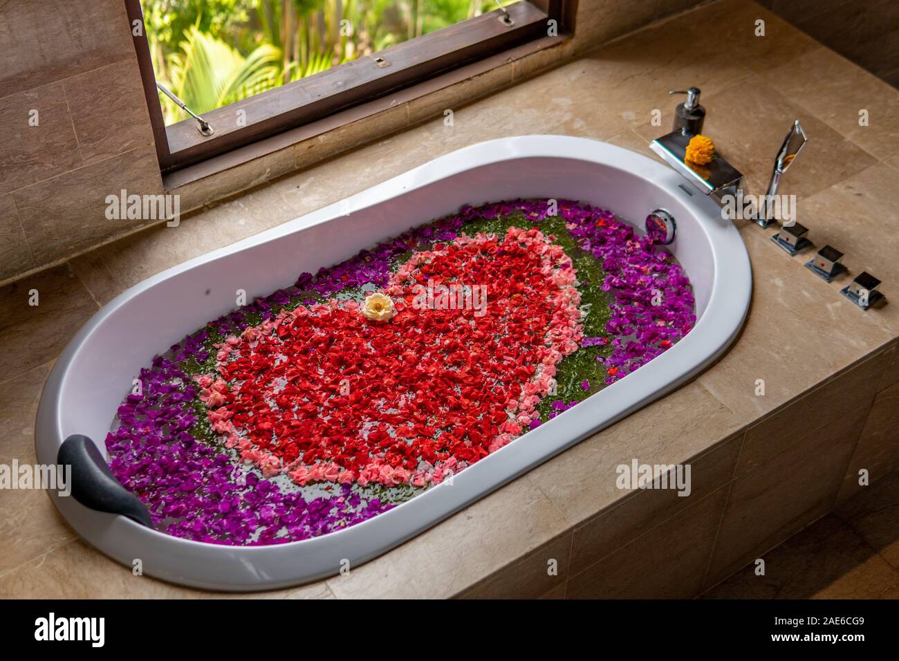 A romantic bath with various flowers making a heart shape with window ...