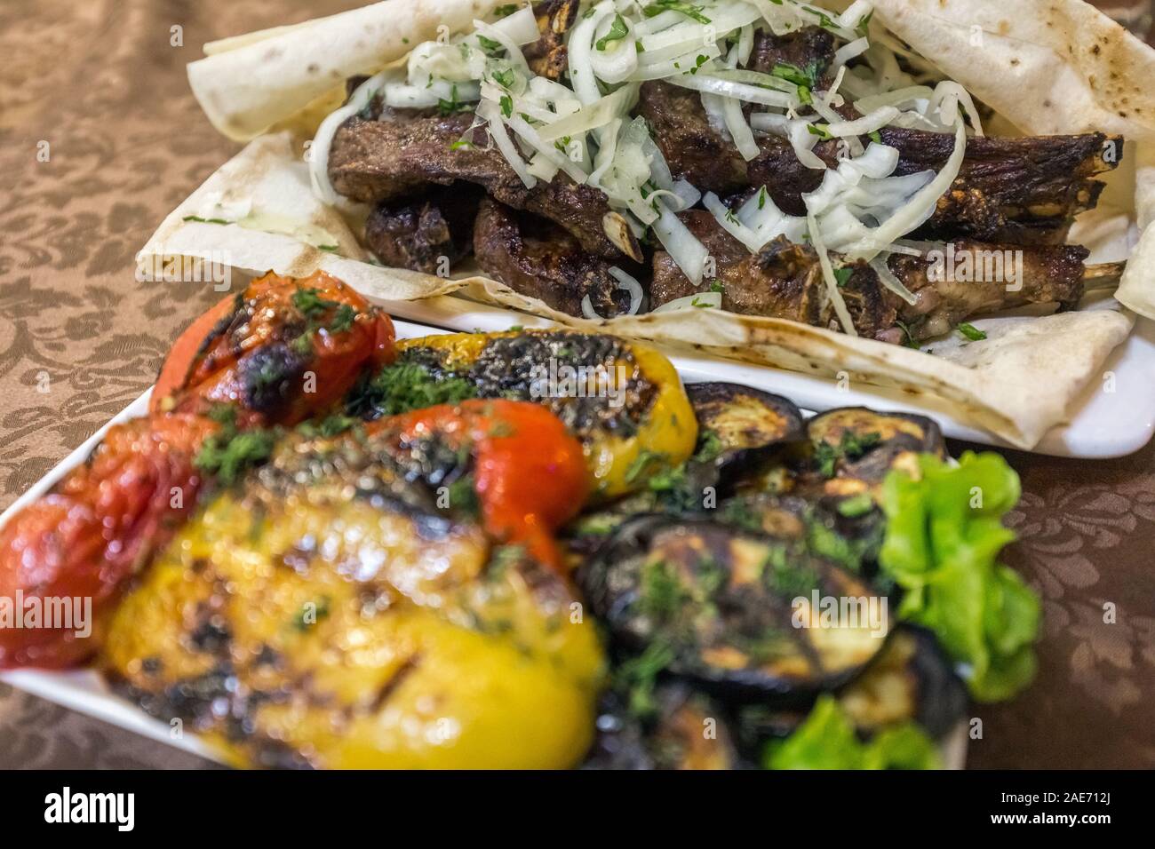 Traditional georgian food - shish kebab and grilled vegetables on a ...