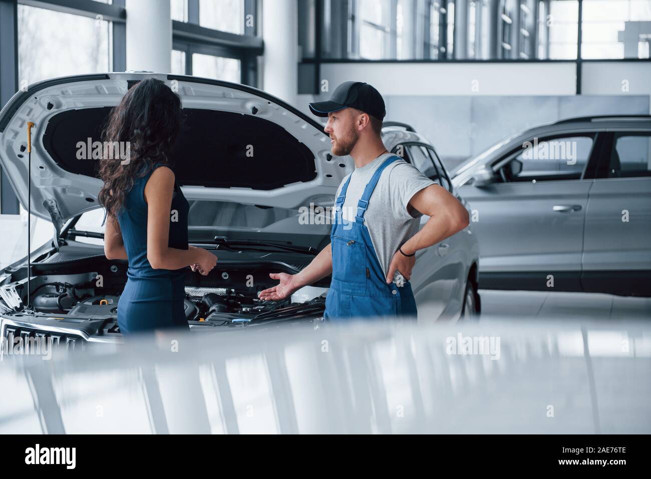 Some details about accident. Woman in the auto salon with employee in ...