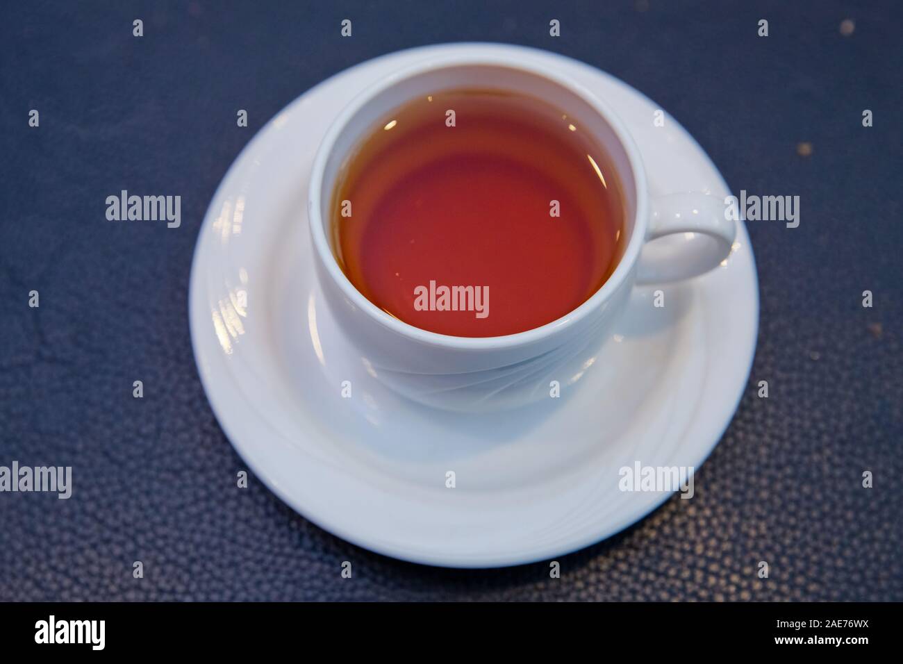 Front view . Tea cup over blue background . White Glass cup isolated on ...