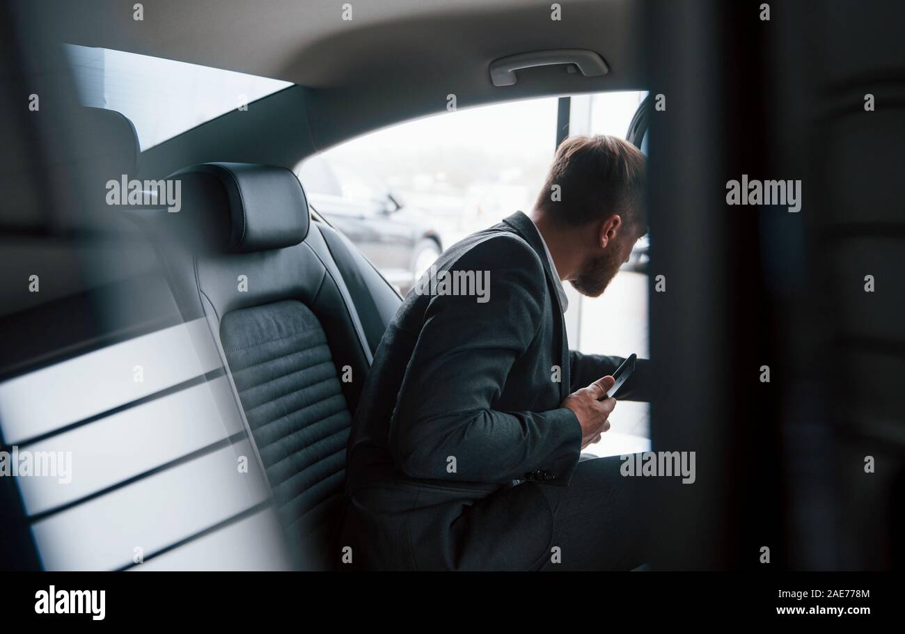 Getting out of the vehicle. Businessman in official wear have call when ...