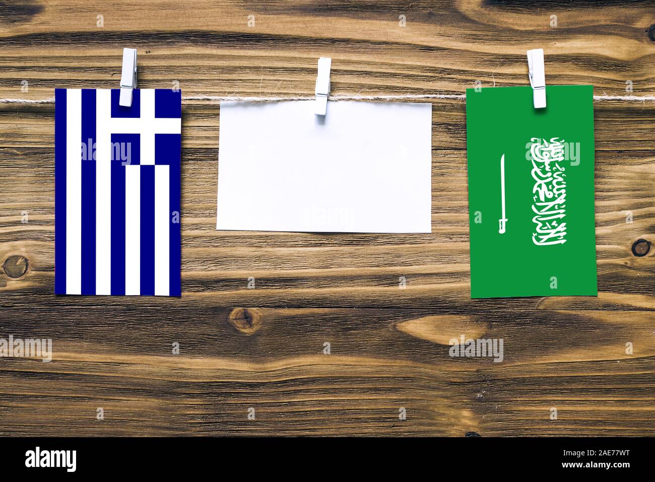 Hanging flags of Greece and Saudi Arabia attached to rope with clothes ...