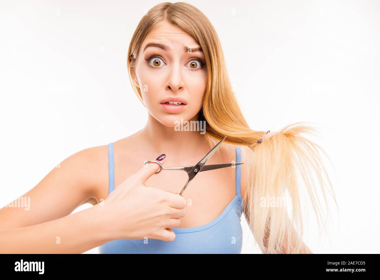 Upset woman cutting her split ends Stock Photo - Alamy