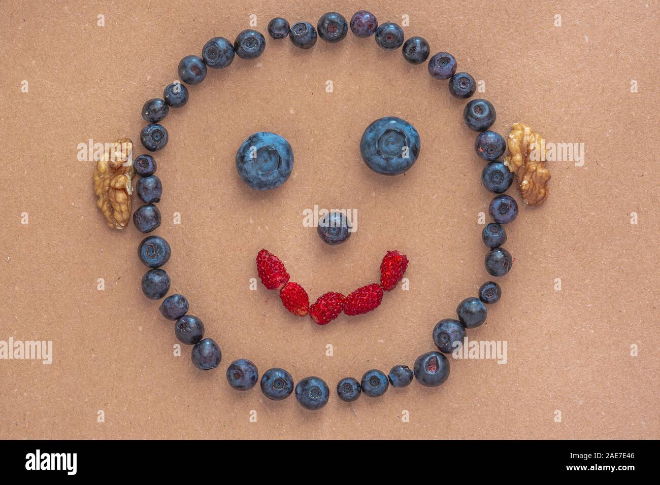 Happy face made from fresh variety of wild berries and nuts, healthy ...