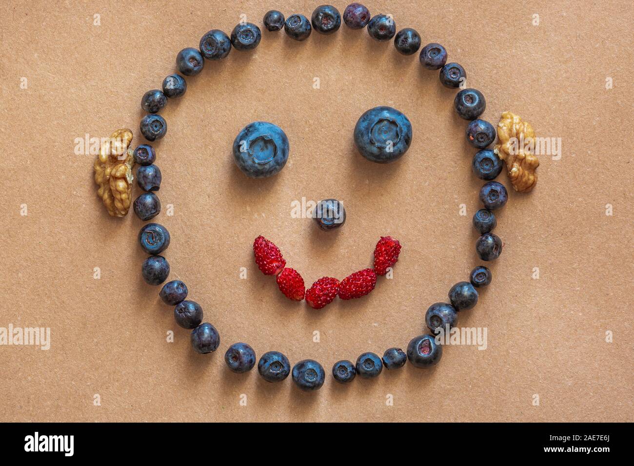 Happy face made from fresh variety of wild berries and nuts, healthy ...
