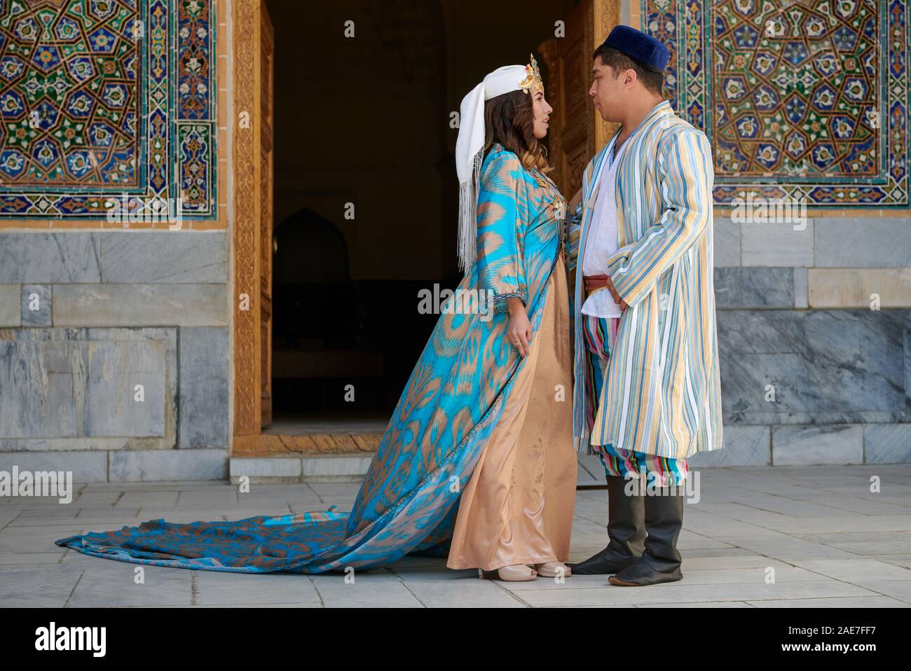bridal couple in traditional clothes posing in front of famous Registan ...