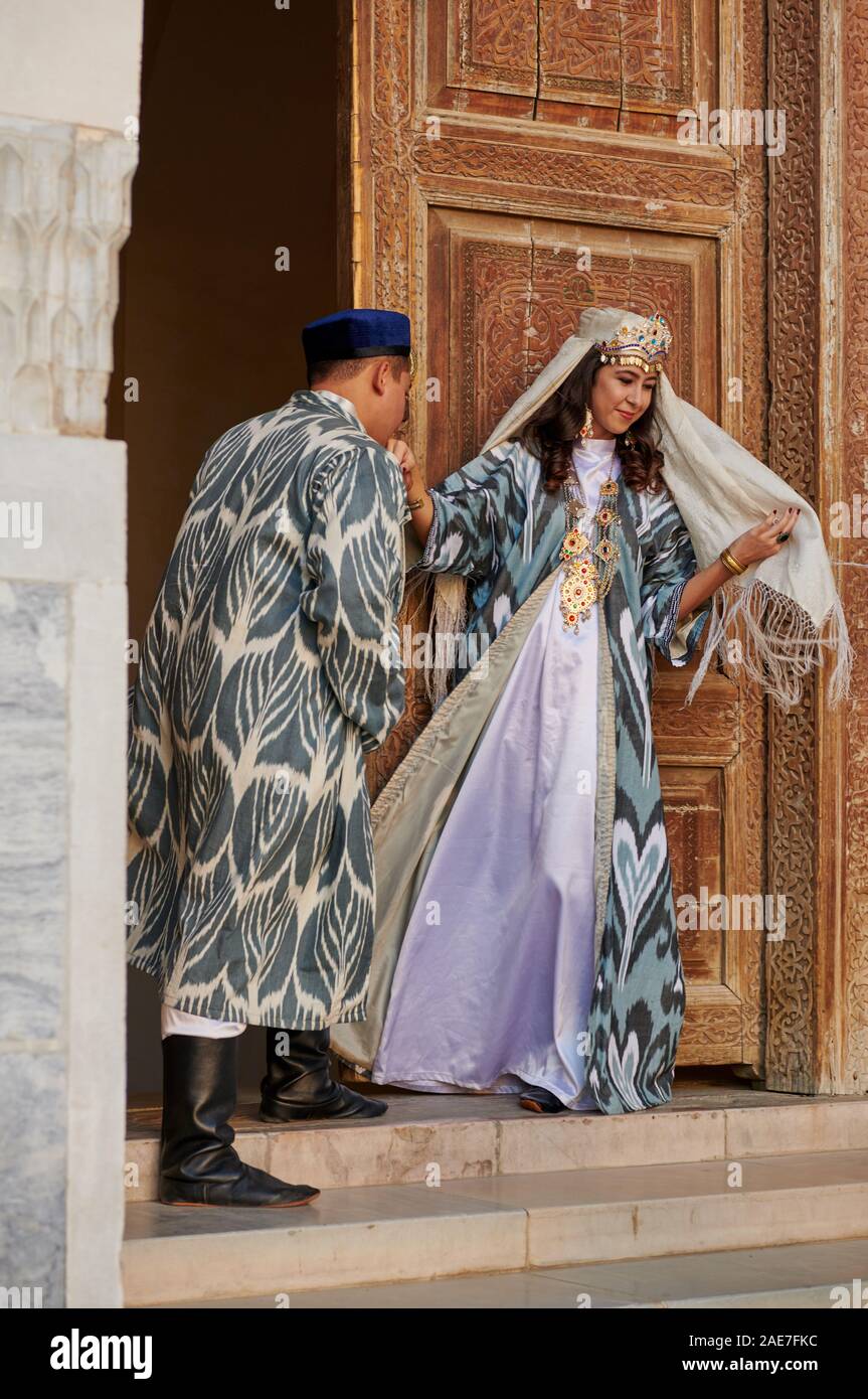 bridal couple in traditional clothes posing in front of famous Registan ...