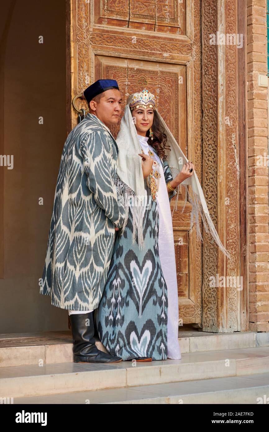 bridal couple in traditional clothes posing in front of famous Registan ...