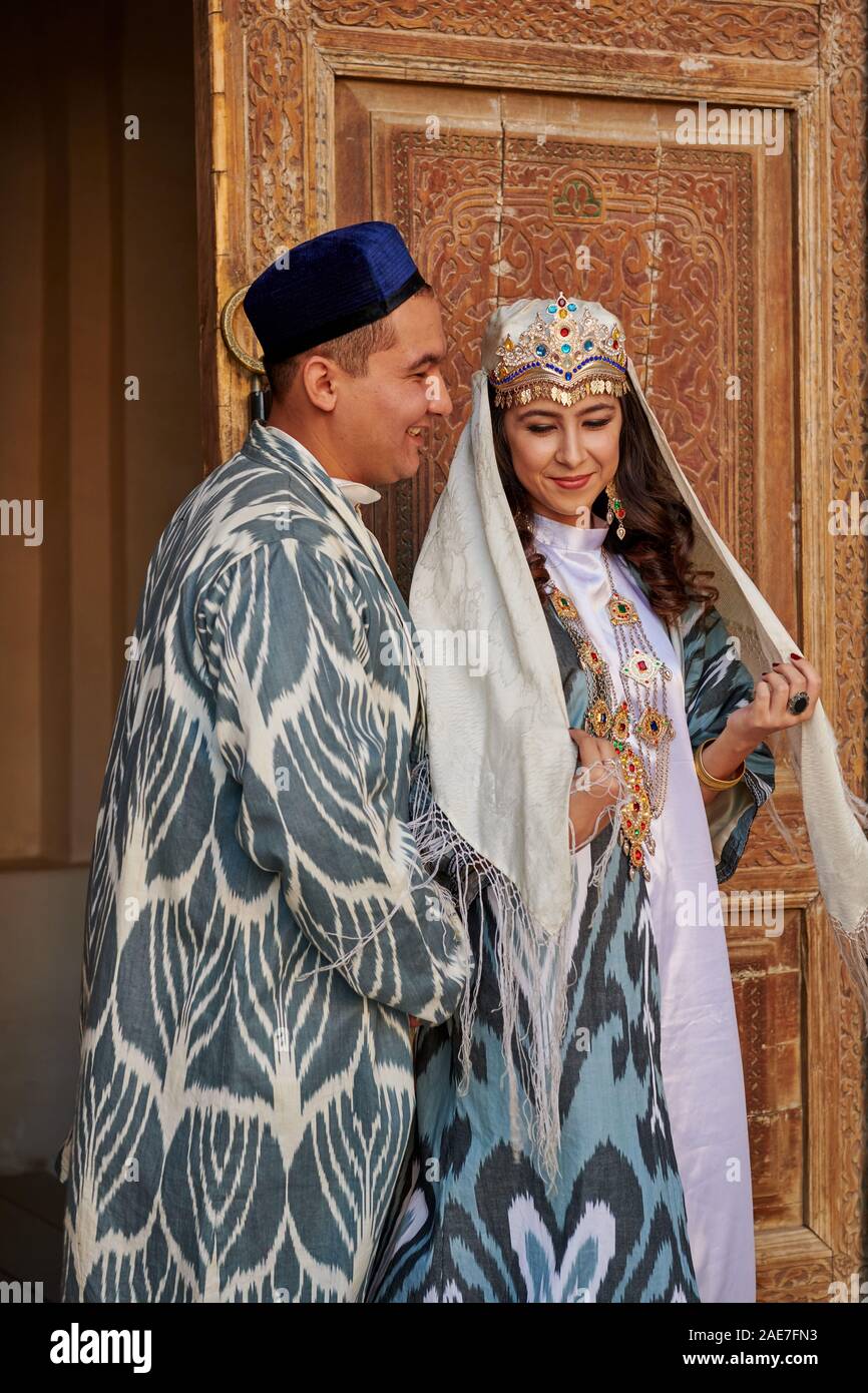 bridal couple in traditional clothes posing in front of famous Registan ...