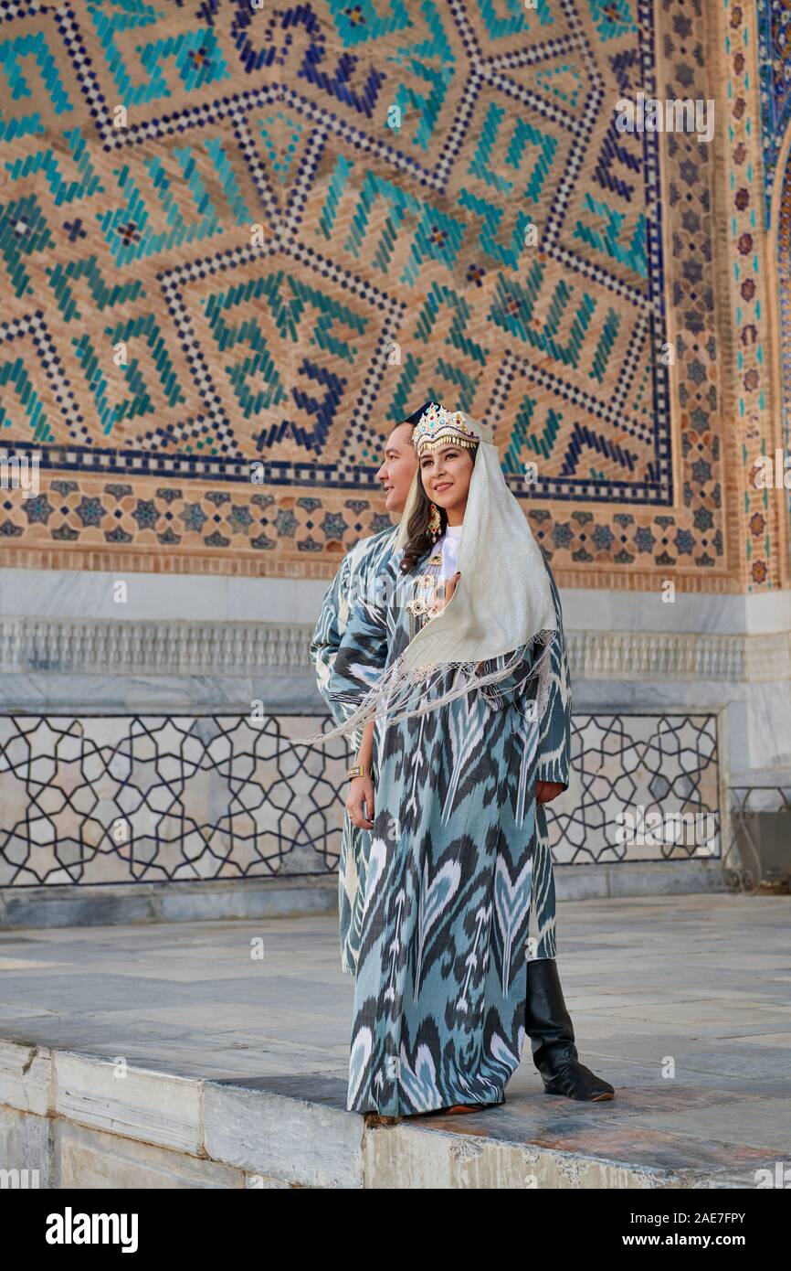 bridal couple in traditional clothes posing in front of famous Registan ...