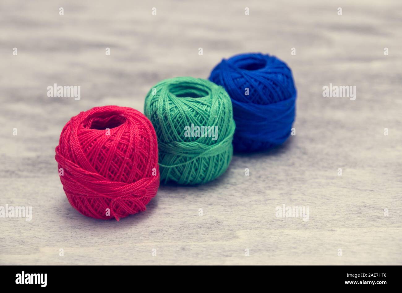 colored woolen thread and needles and meter close up on a wood ...
