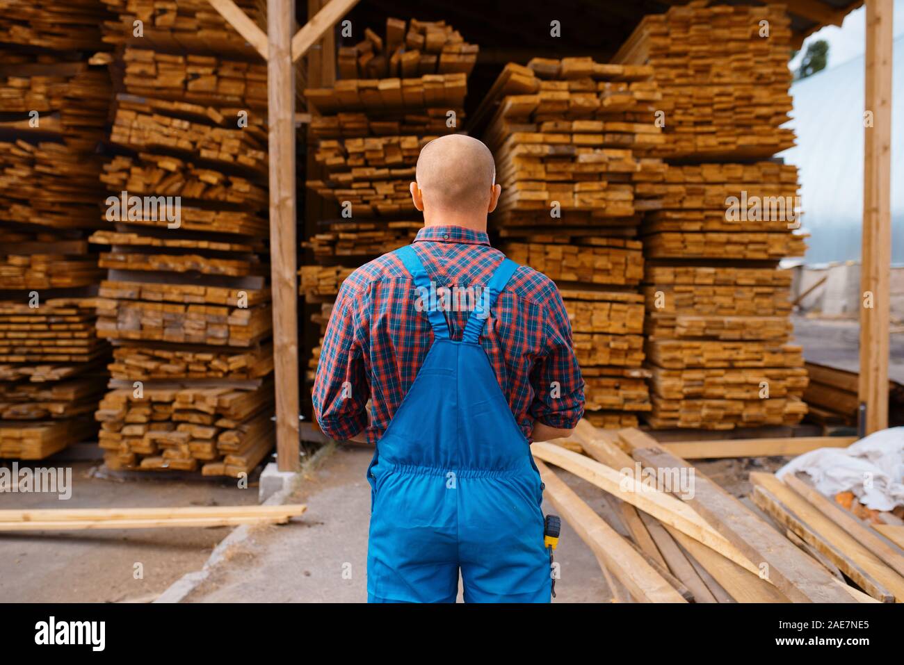 Joiner in uniform check boards on timber mill Stock Photo - Alamy