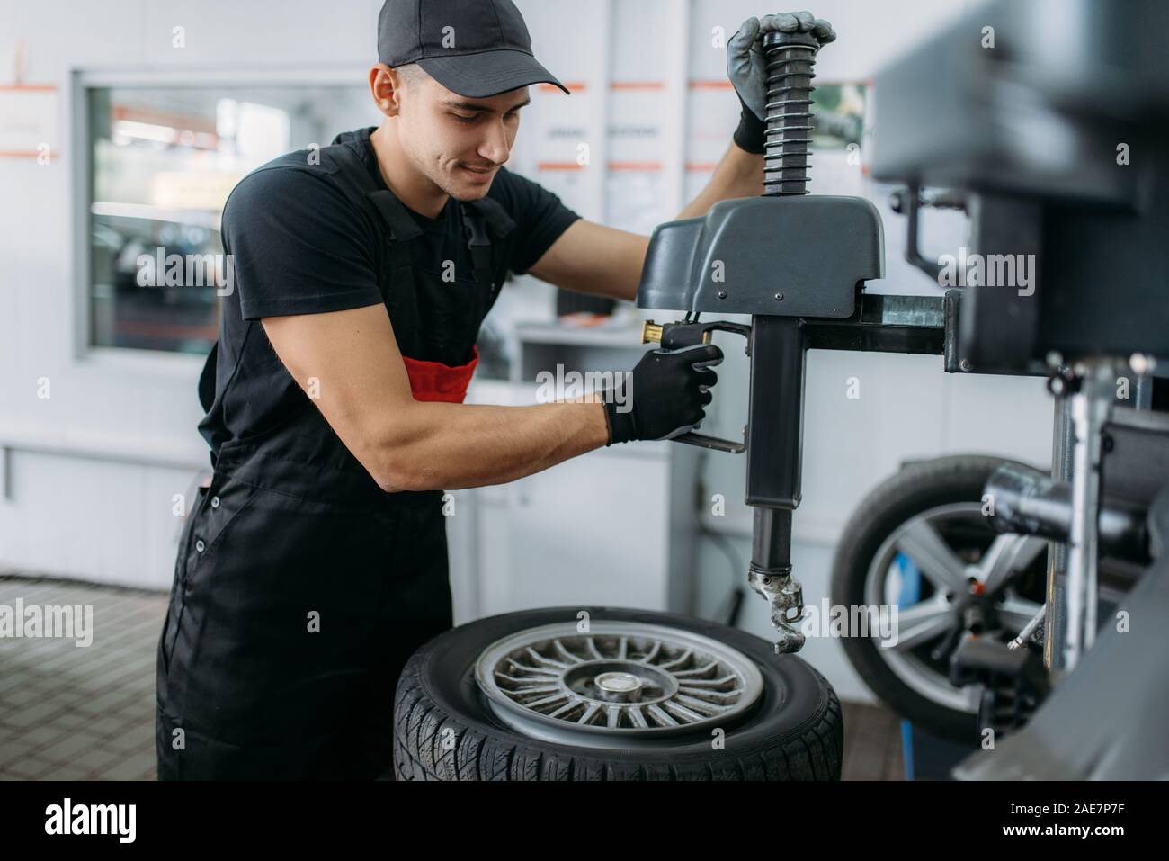 Mechanic fixing wheel on tire fitting machine Stock Photo - Alamy