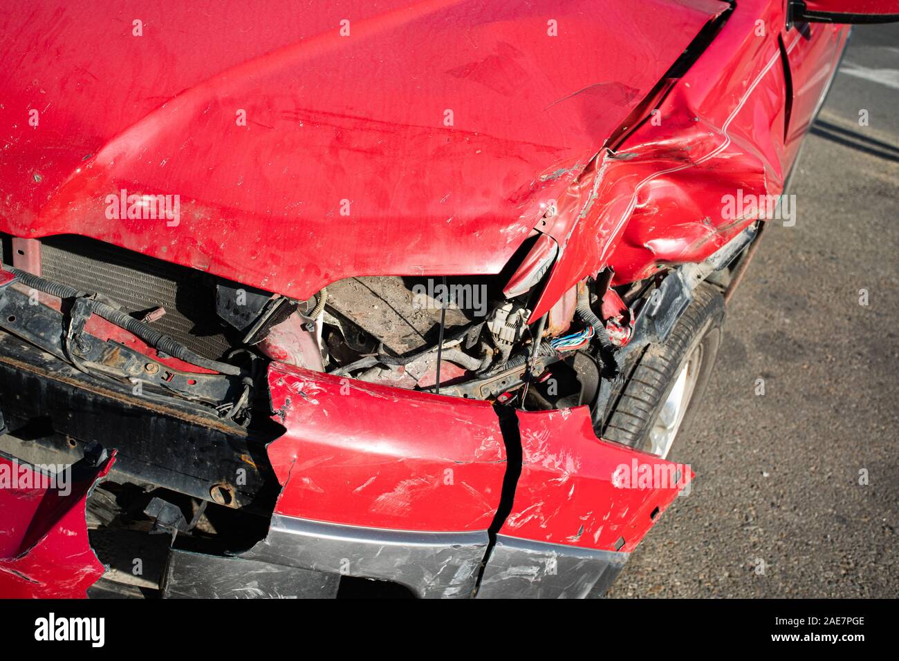 Front of red car get damaged by accident on the road Stock Photo - Alamy