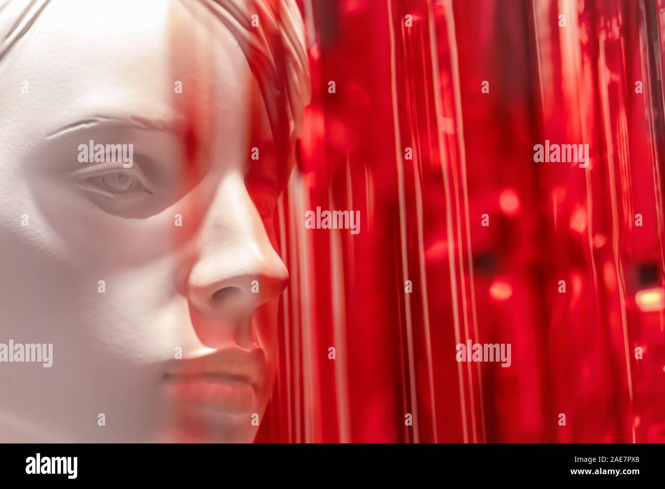 stylish beauty mannequin female head on a blurred bright colored red ...