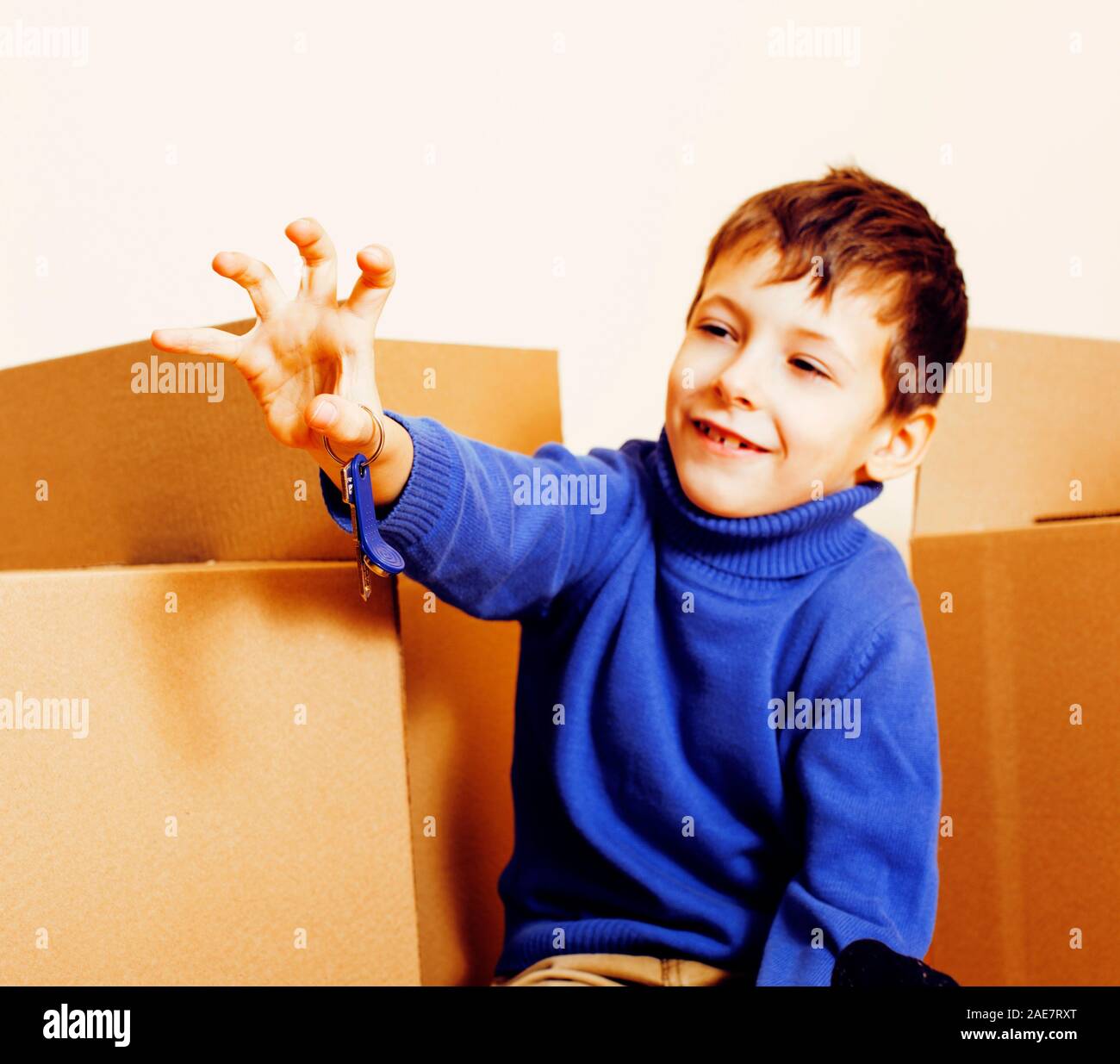 little cute boy in empty room with many boxes, remoove to new home ...