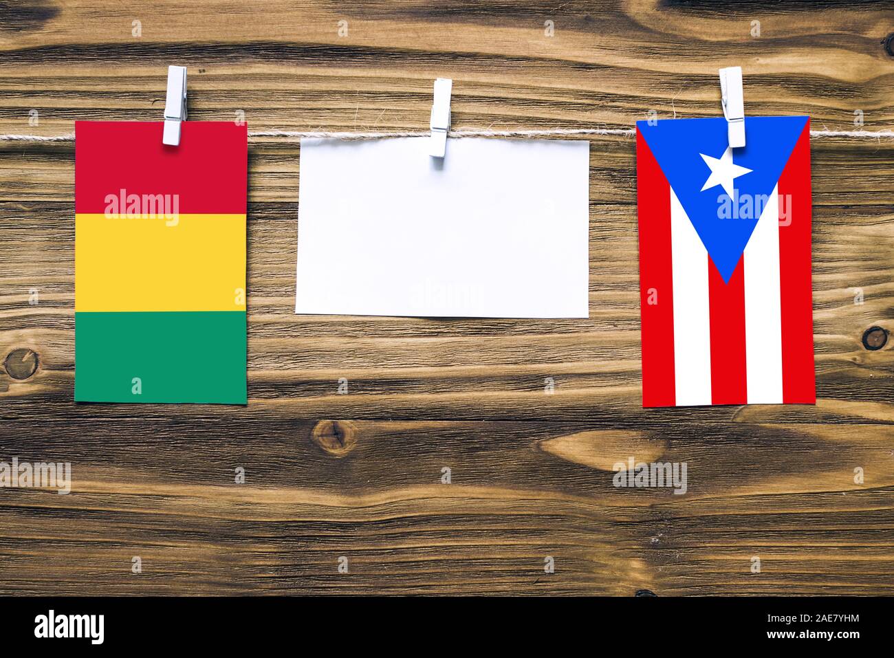 Hanging flags of Guinea and Puerto Rico attached to rope with clothes ...