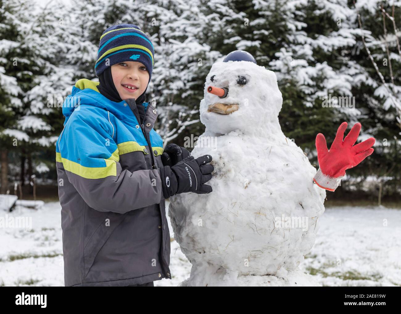 A child - boy with his self created snowman. Winter time in Poland ...