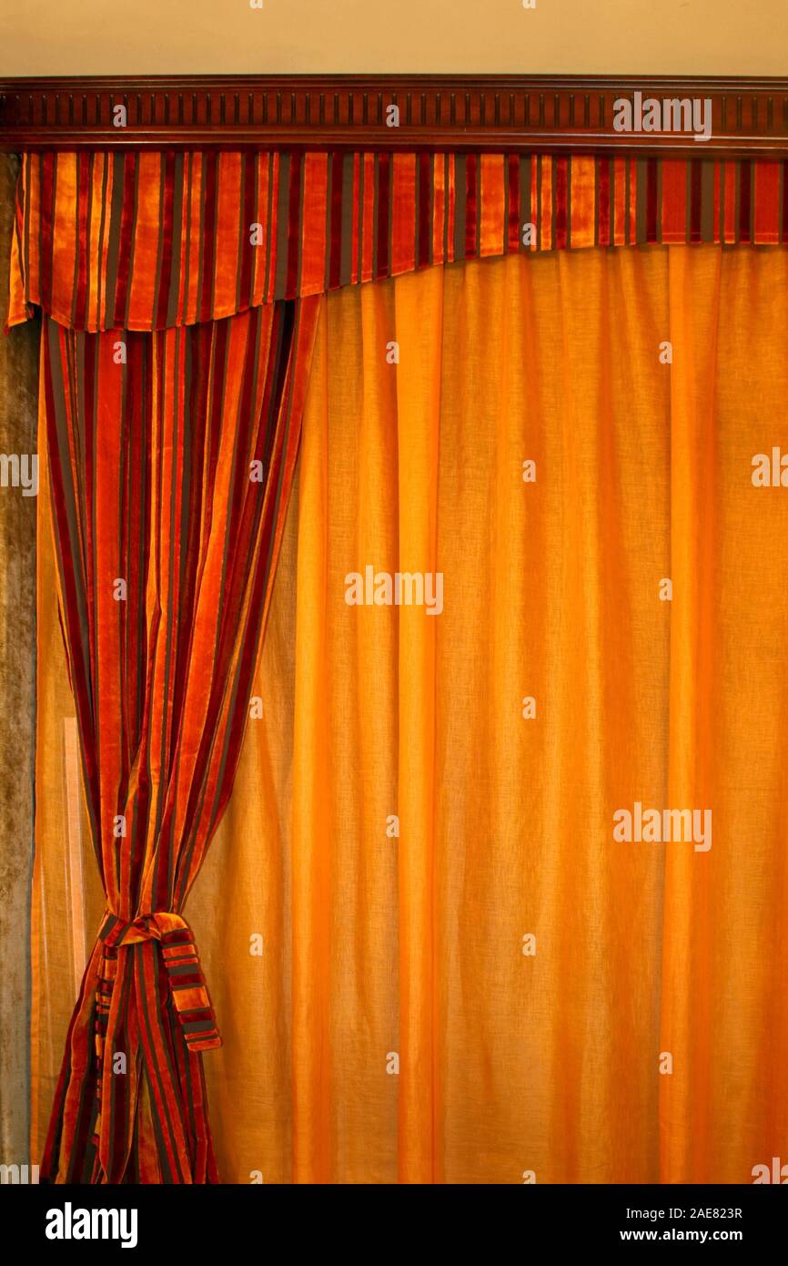 Orange drapery with red curtains made from velvet Stock Photo - Alamy