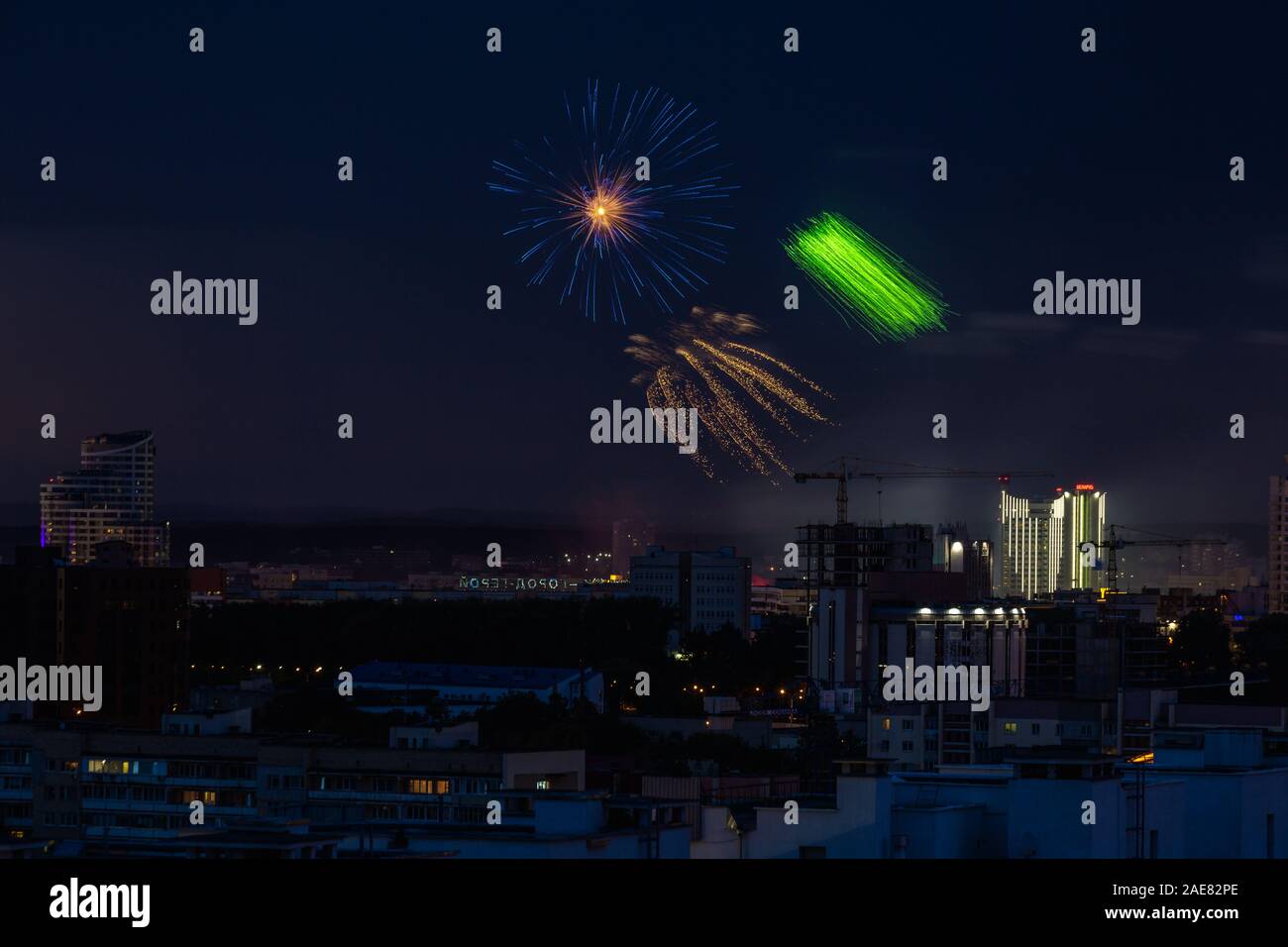Fireworks light up the sky over night city. During this event person ...