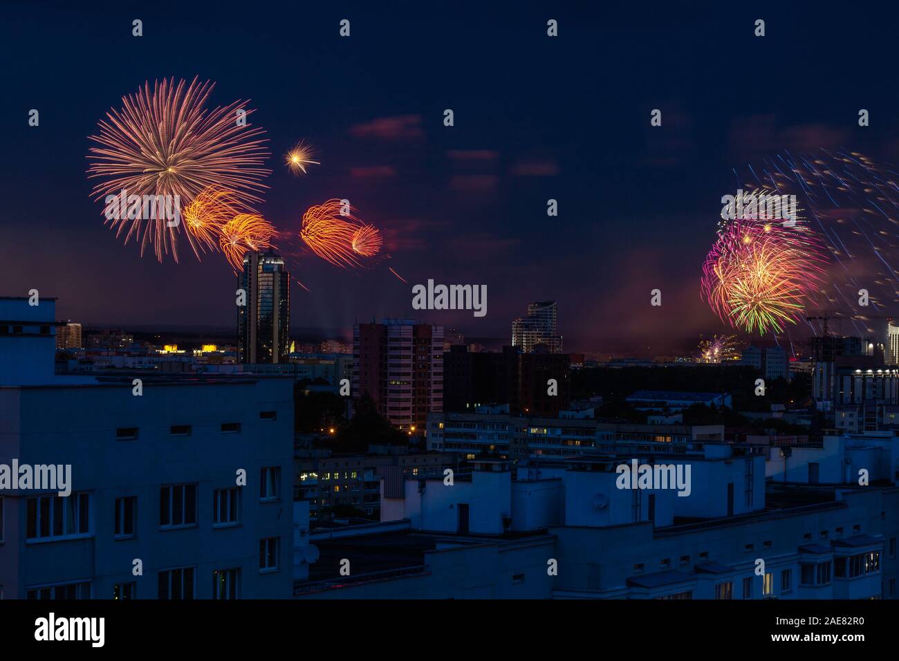 Fireworks light up the sky over night city. During this event person ...