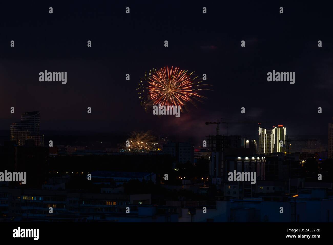 Fireworks light up the sky over night city. During this event person ...