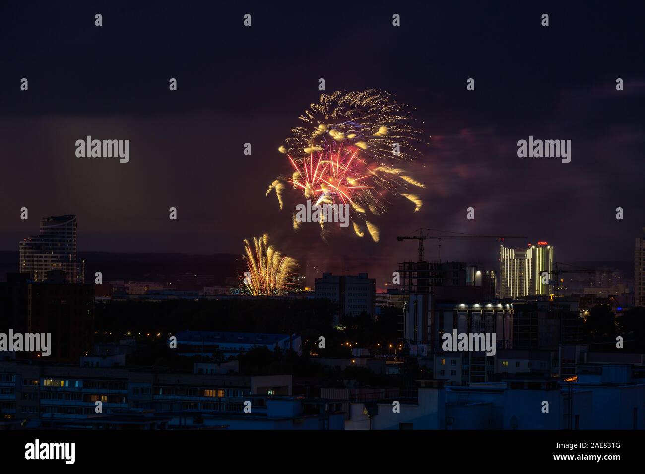 Fireworks light up the sky over night city. During this event person ...