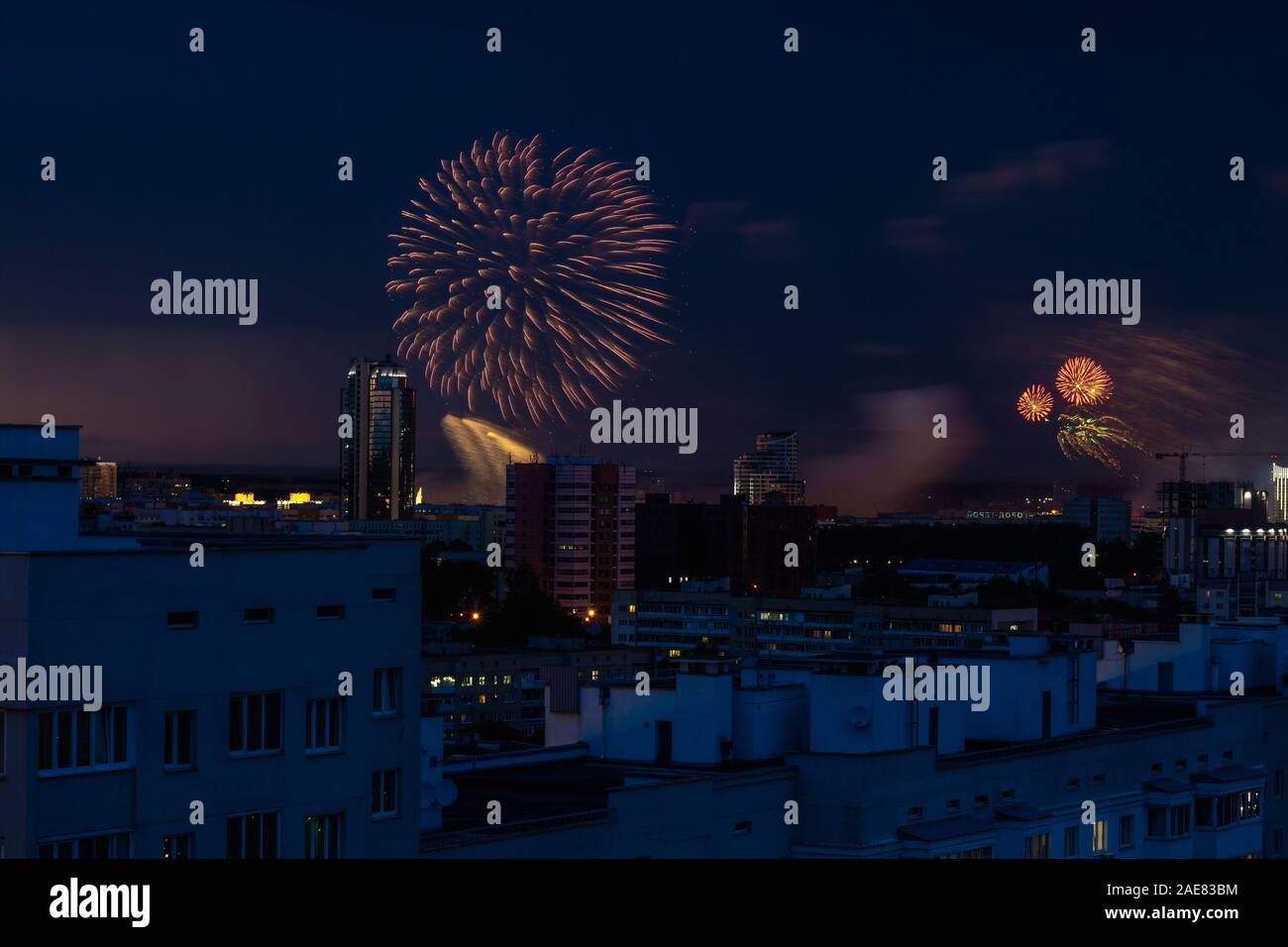 Fireworks light up the sky over night city. During this event person ...