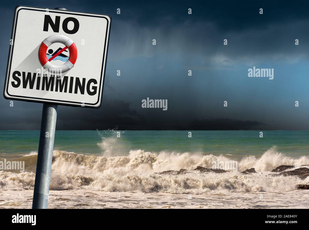 No swimming. Danger sign at the beach with a rough sea with rainy sky ...