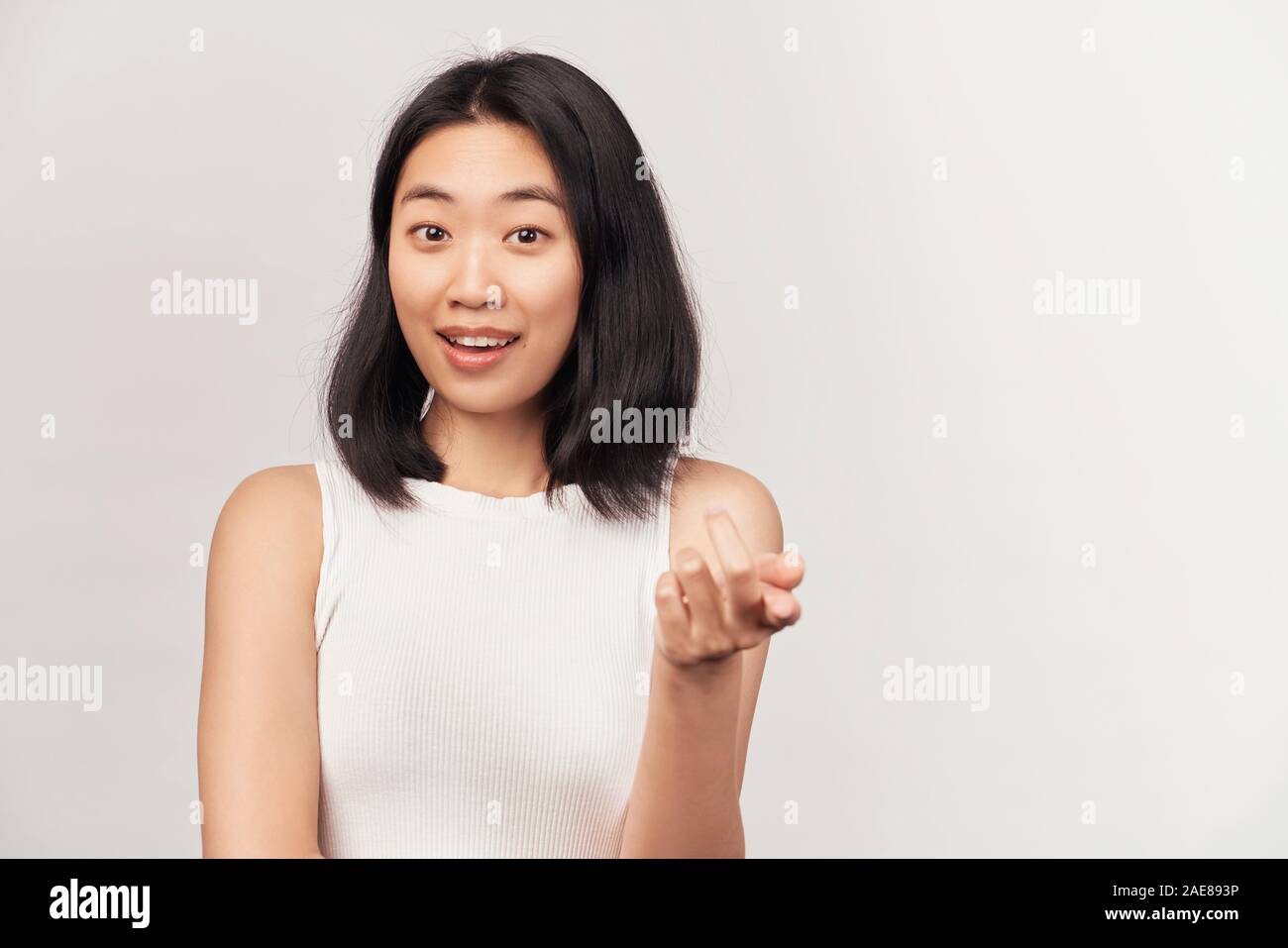 Smiling positive young female points at camera Stock Photo - Alamy