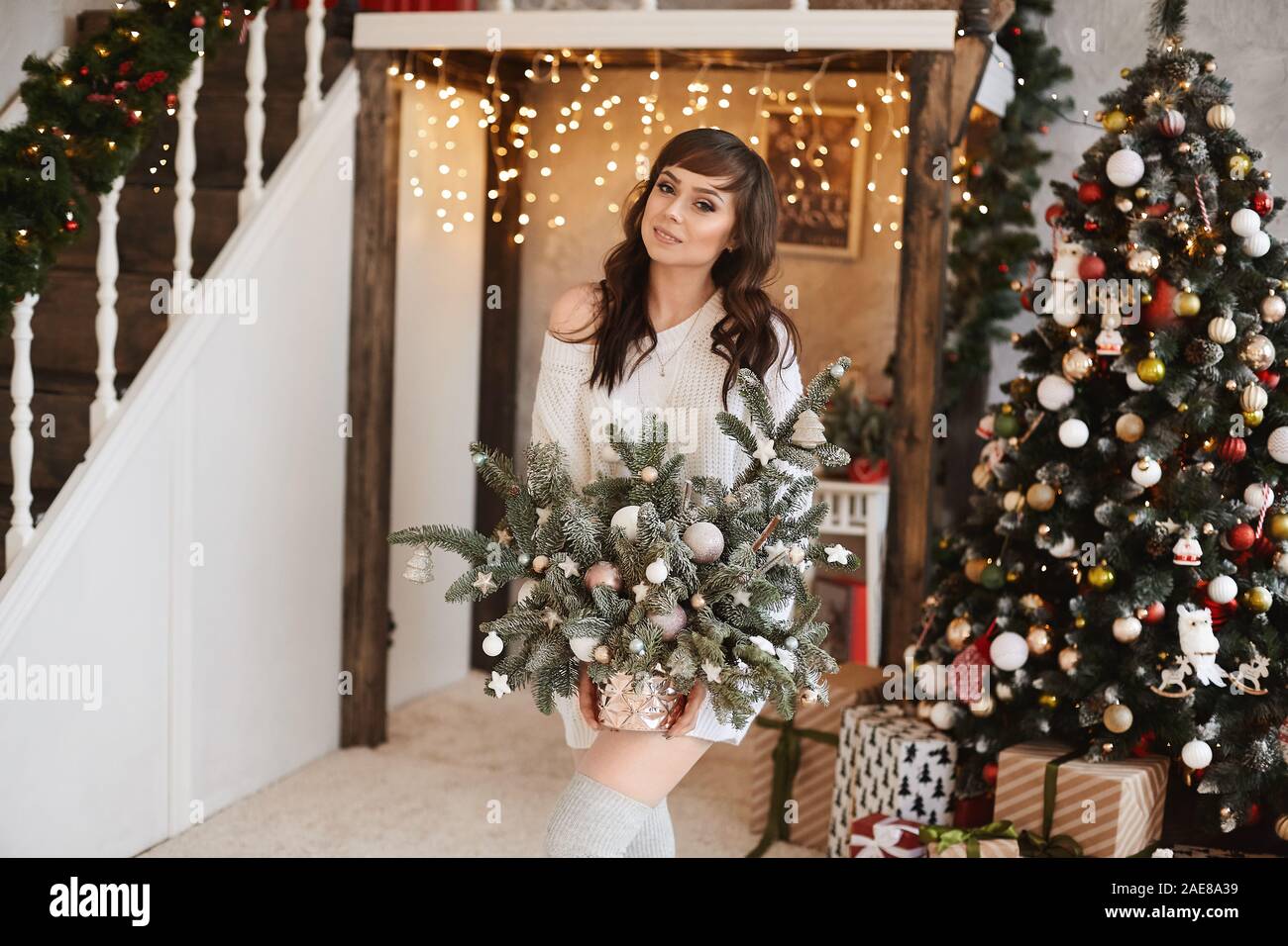 Christmas fashion photo of beautiful model girl in cozy clothes keeps ...