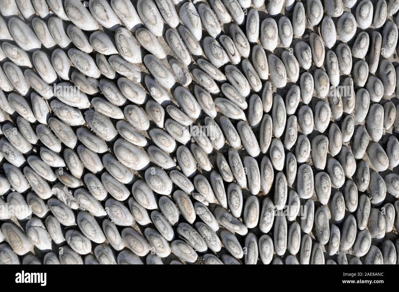 The sidewalk or wall of small pebbles lined with a pattern. Art ...