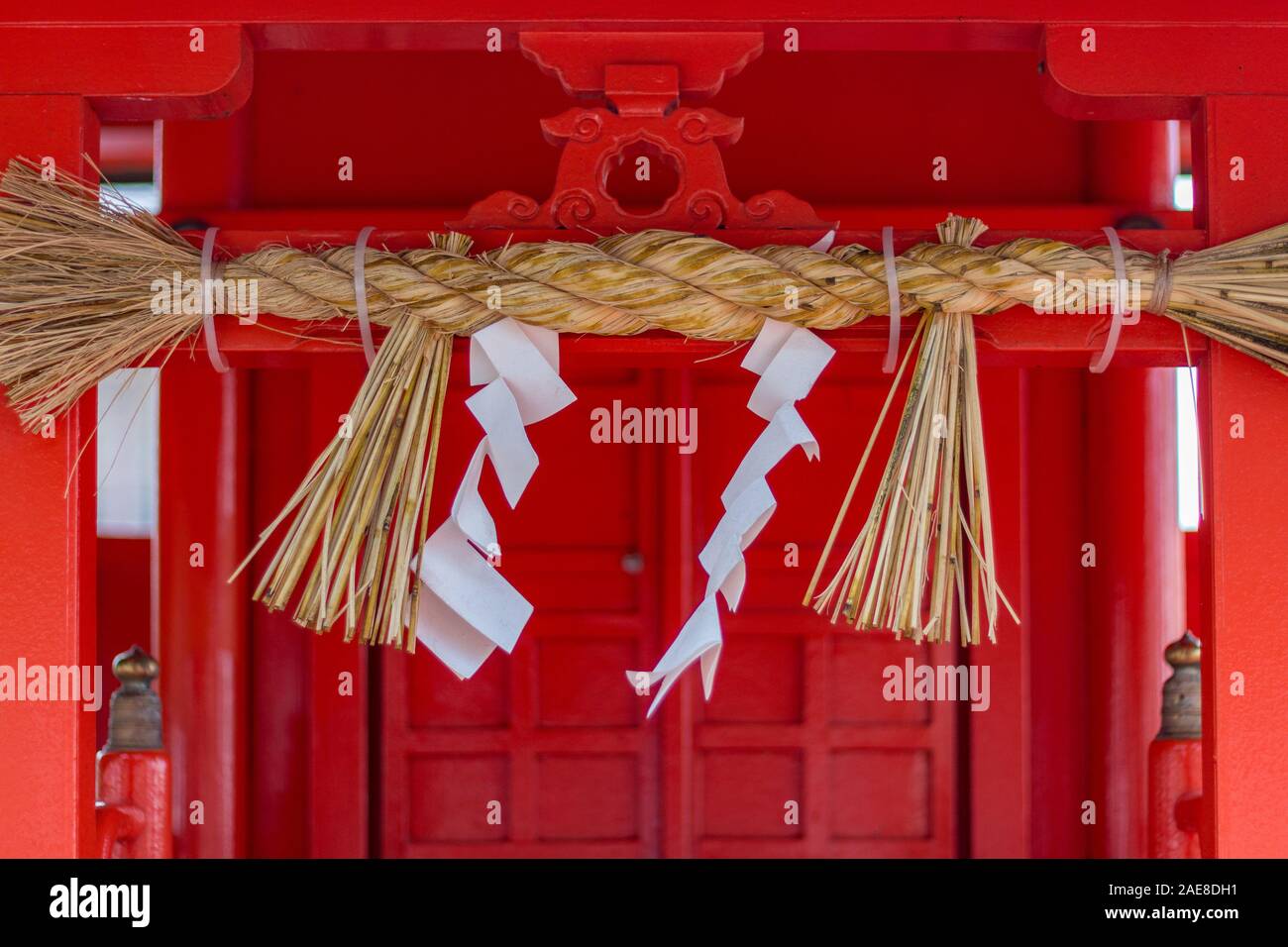 Close up of sacred rope, or shimenawa, and shide, paper streamers, at ...