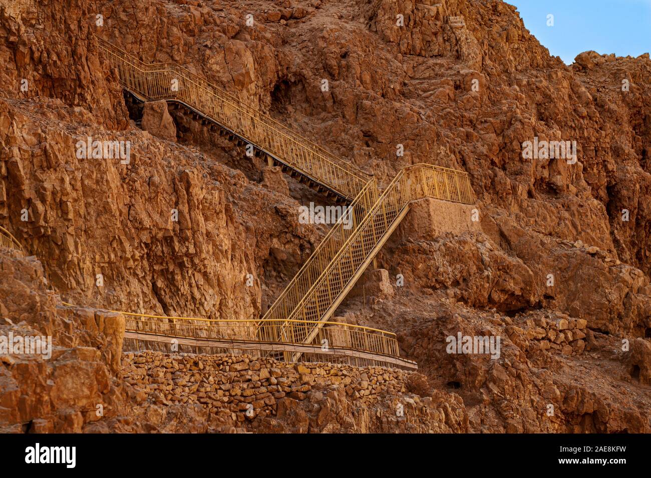 Steep side of Masada rock with metal stairway for tourists. Israel ...