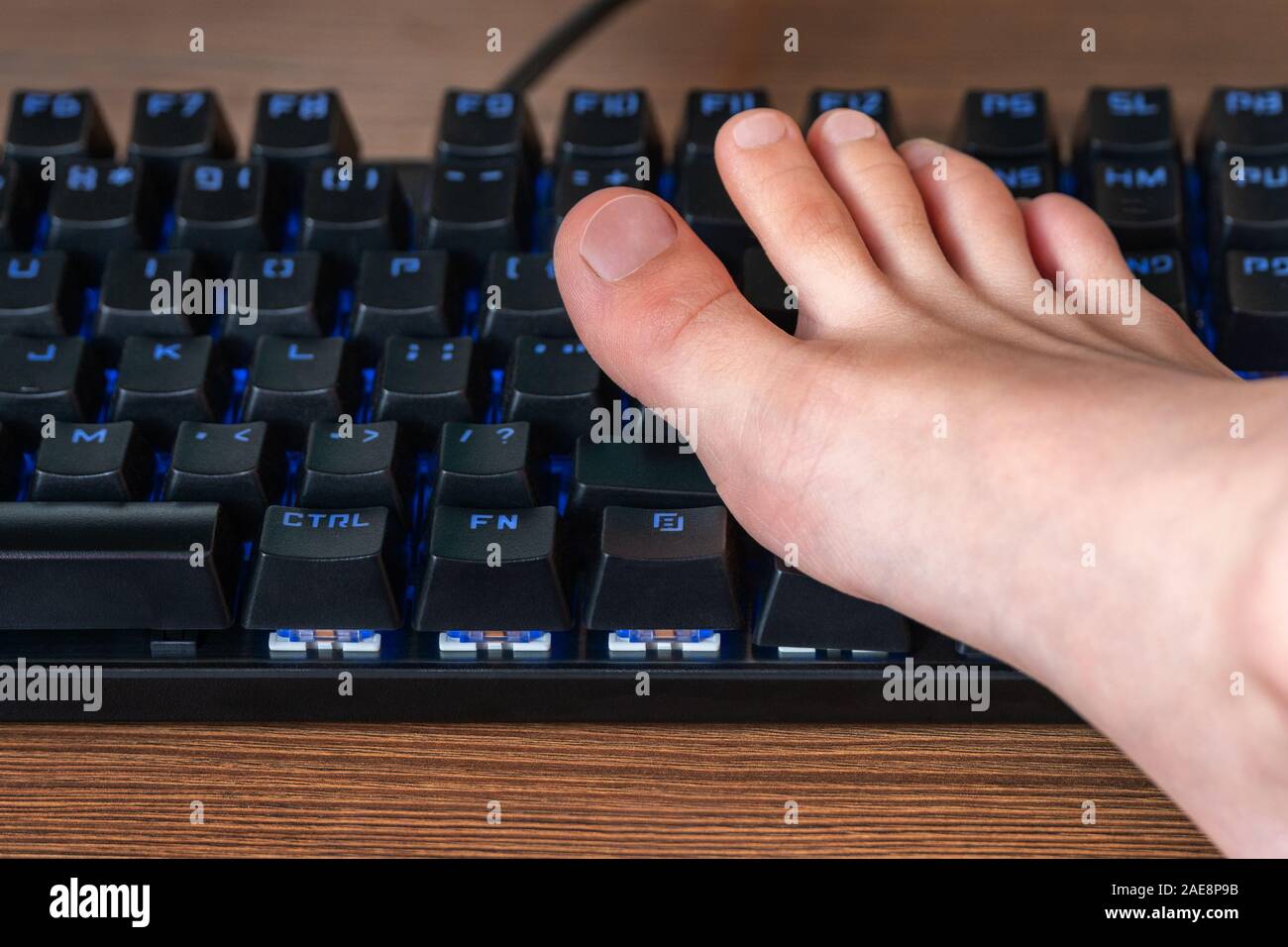 Children foot on a black keyboard with blue backlight Stock Photo - Alamy