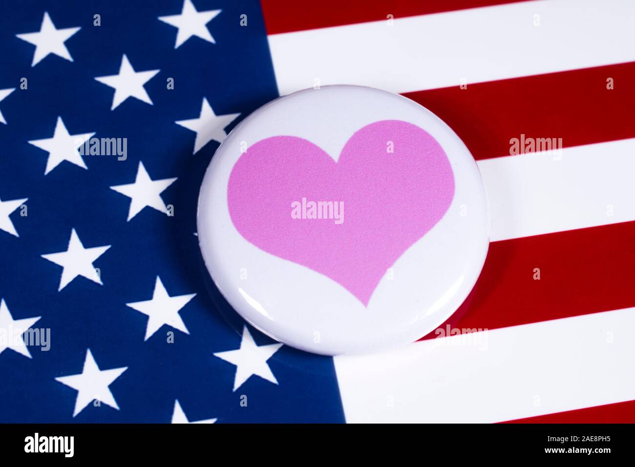 A pink heart symbol, pictured over the flag of the United States of ...