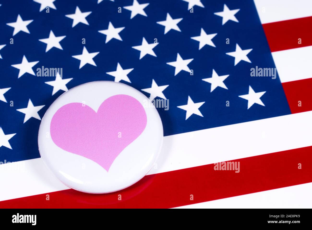 A pink heart symbol, pictured over the flag of the United States of ...