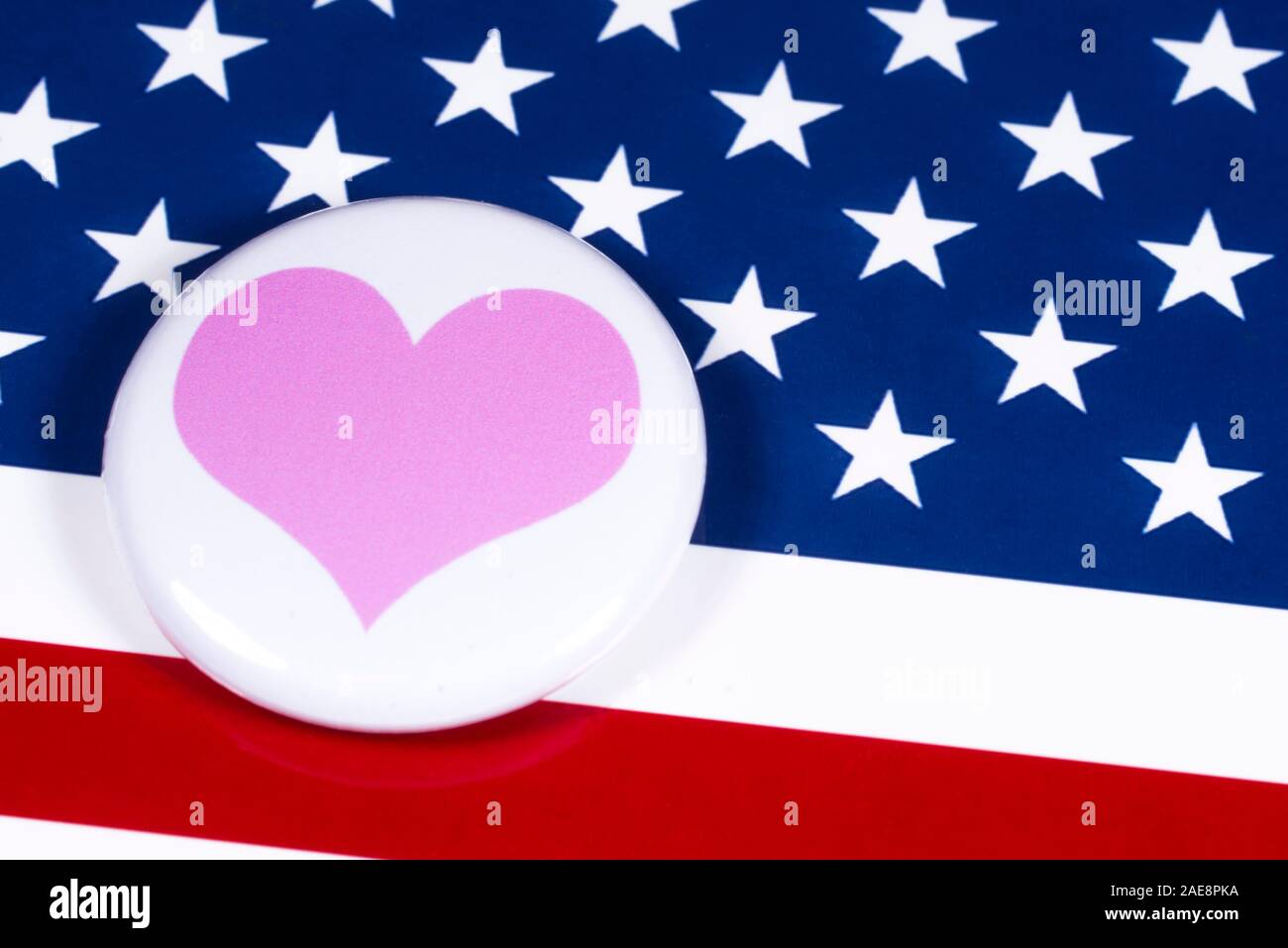 A pink heart symbol, pictured over the flag of the United States of ...