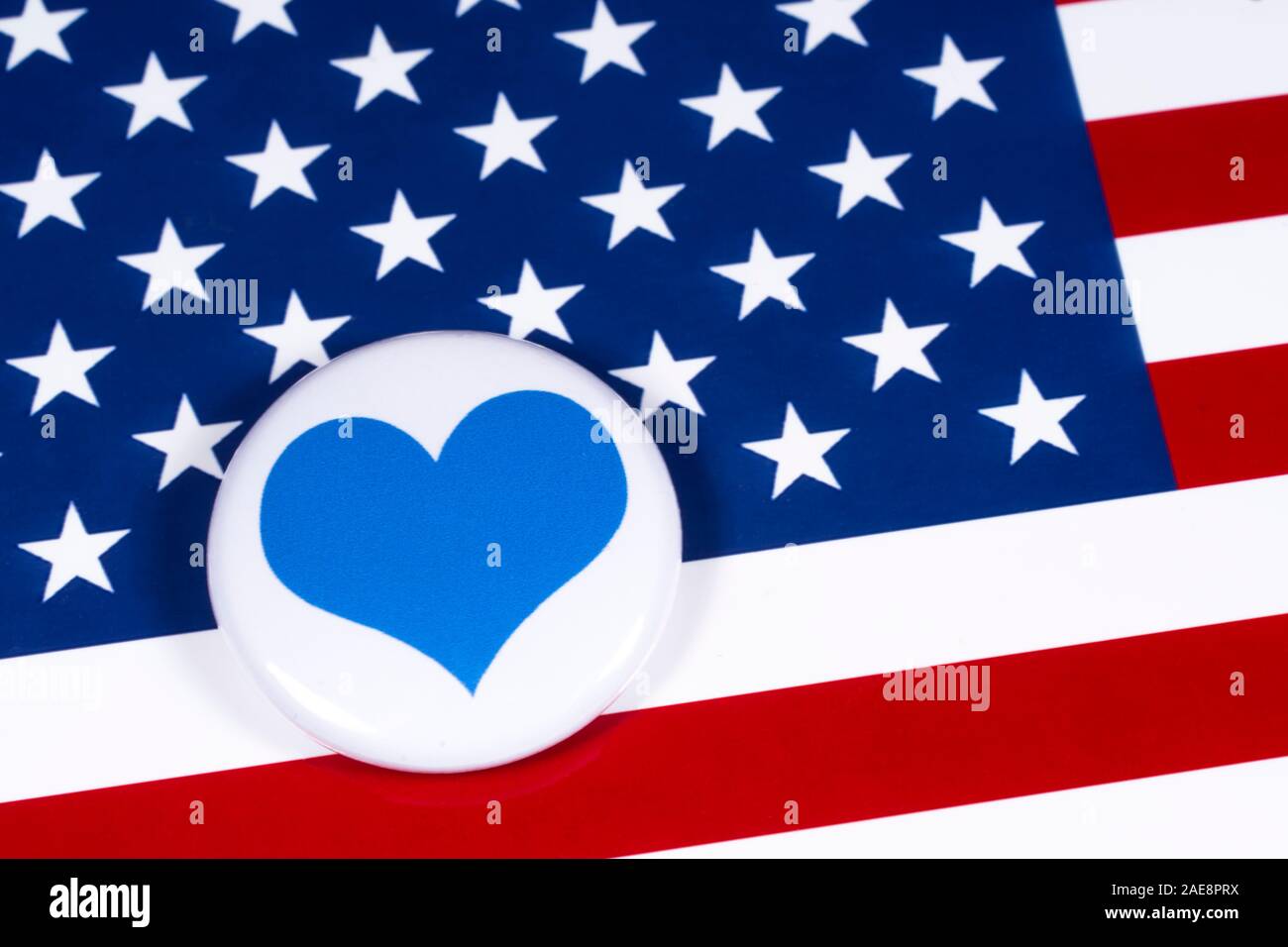 A blue heart symbol, pictured over the flag of the United States of ...